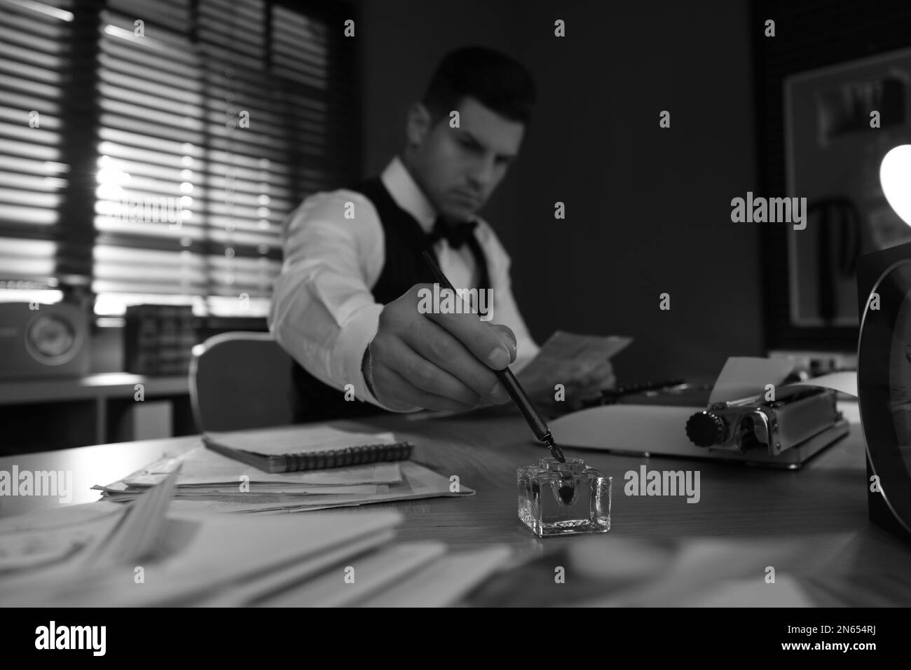 Old fashioned detective working at table in office, focus on hand with ...