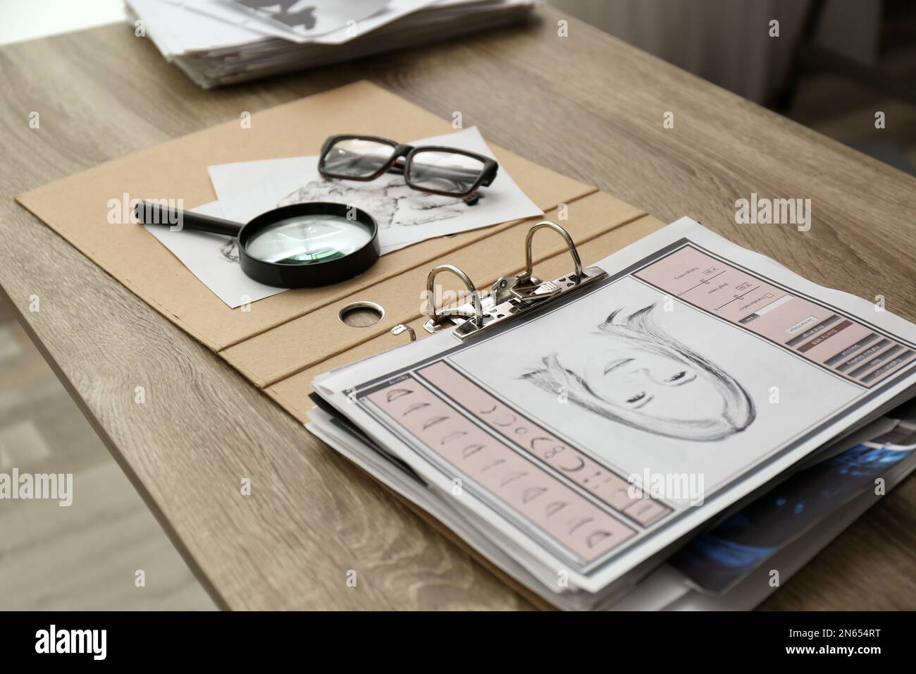 Papers with suspect's portrait, palm print and magnifying glass on ...