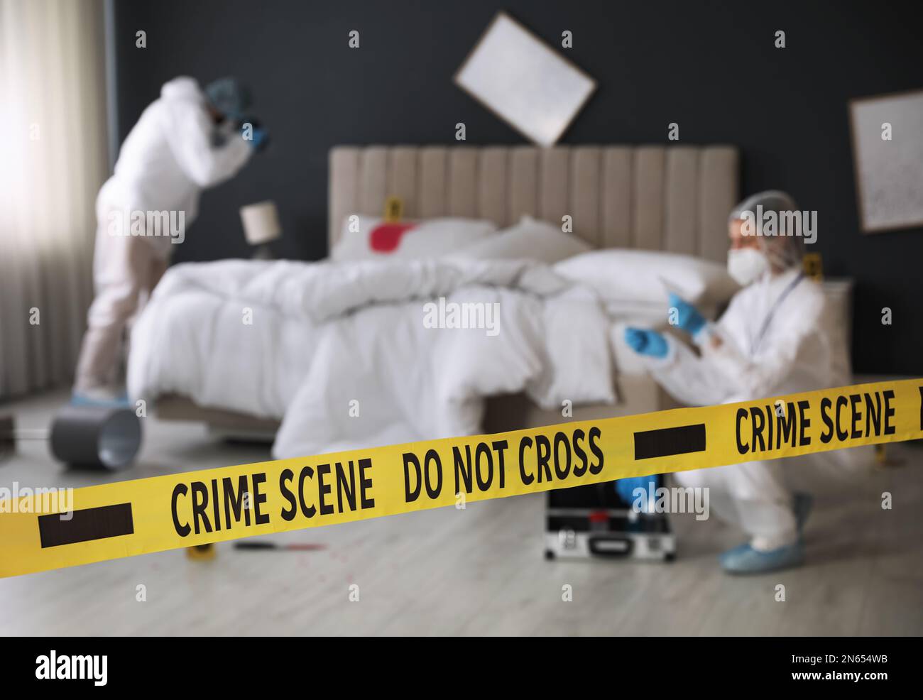 Investigators working at crime scene in messy room, focus on yellow ...