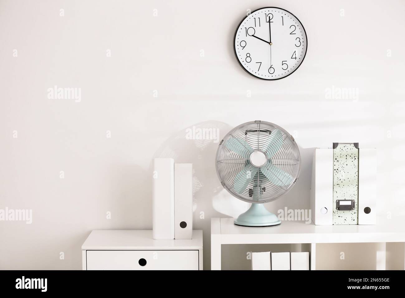 Modern electric fan on shelving unit in office. Space for text Stock ...