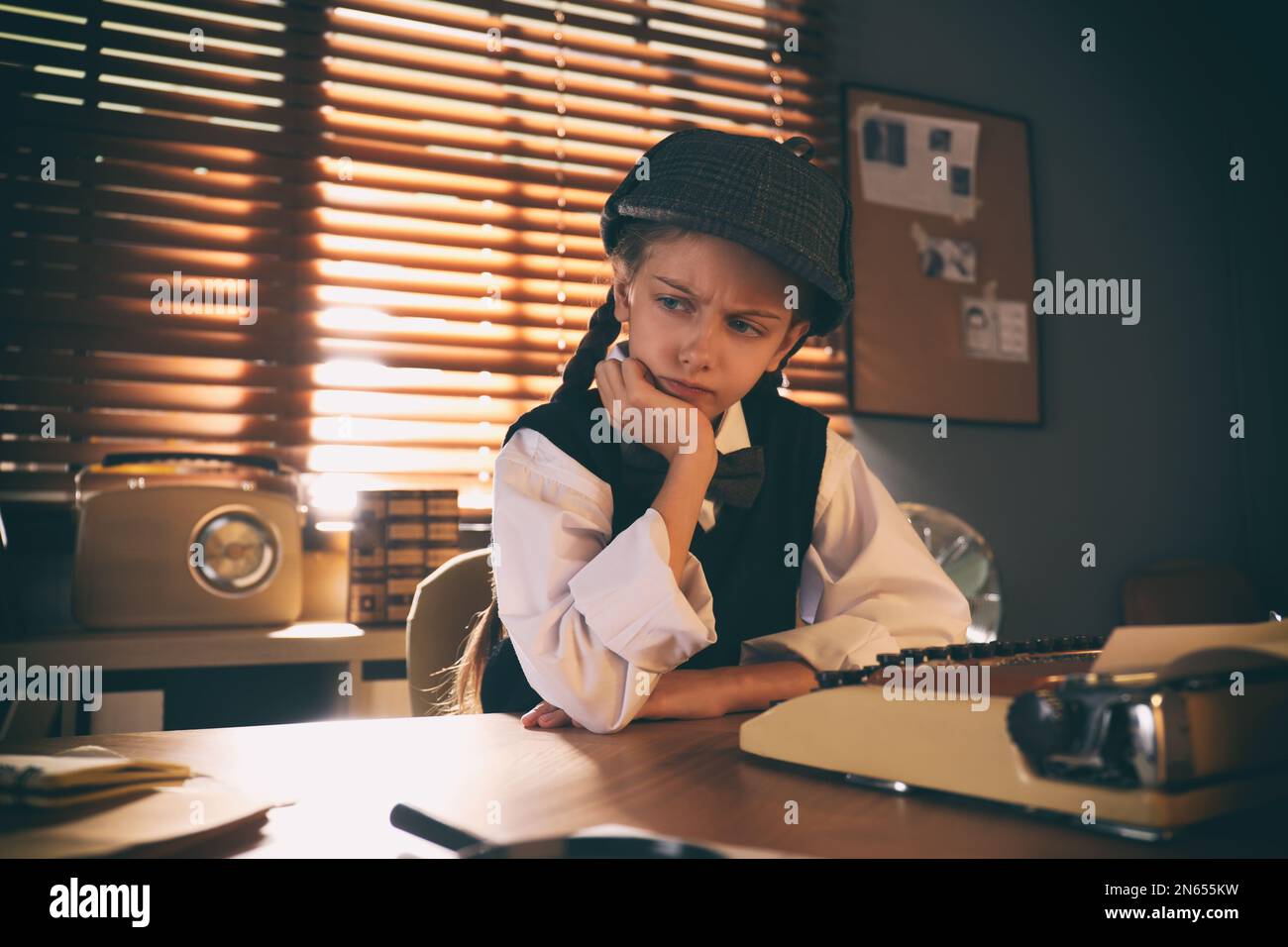 Cute little detective at table in office Stock Photo - Alamy