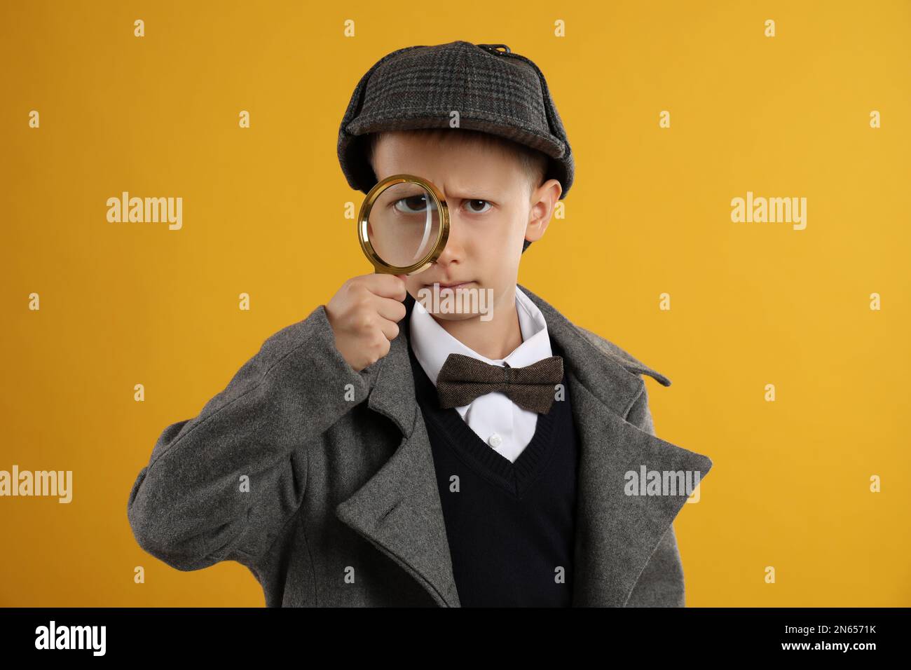 Cute little detective with magnifying glass on yellow background Stock ...