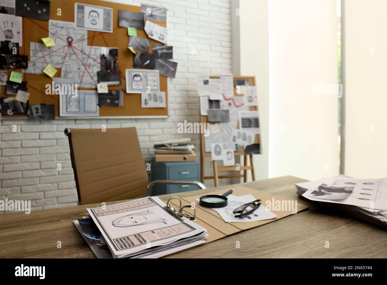 Papers with suspect's portrait, fingerprints and magnifying glass on ...