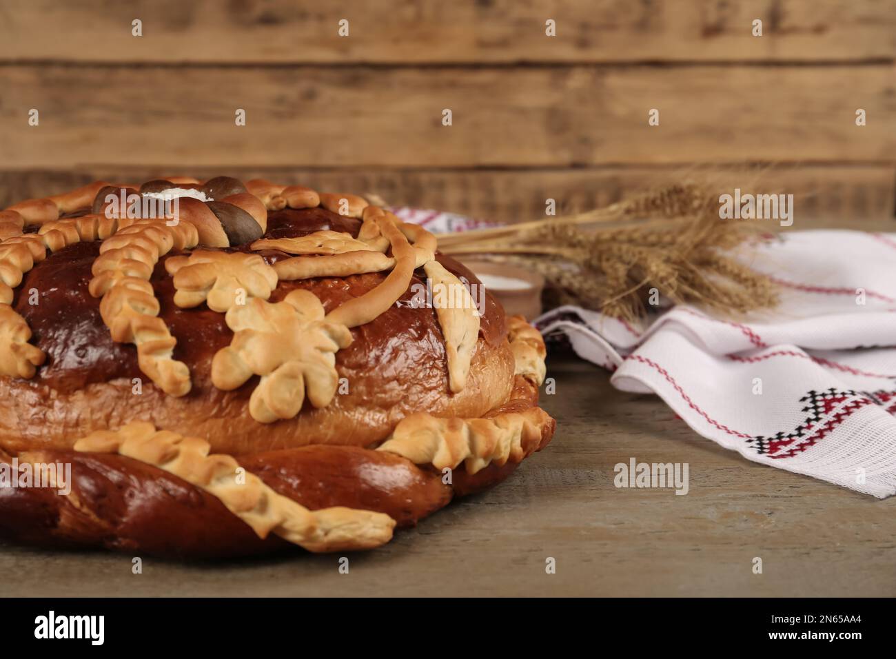 Fresh korovai on wooden table, space for text. Ukrainian bread and salt ...