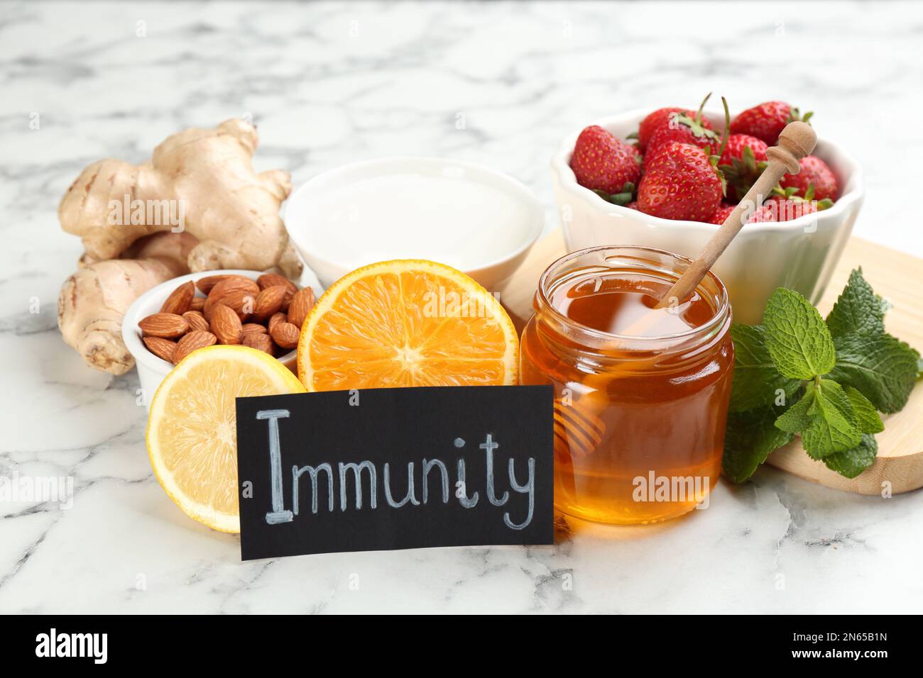 Card with word Immunity and fresh products on light marble background ...