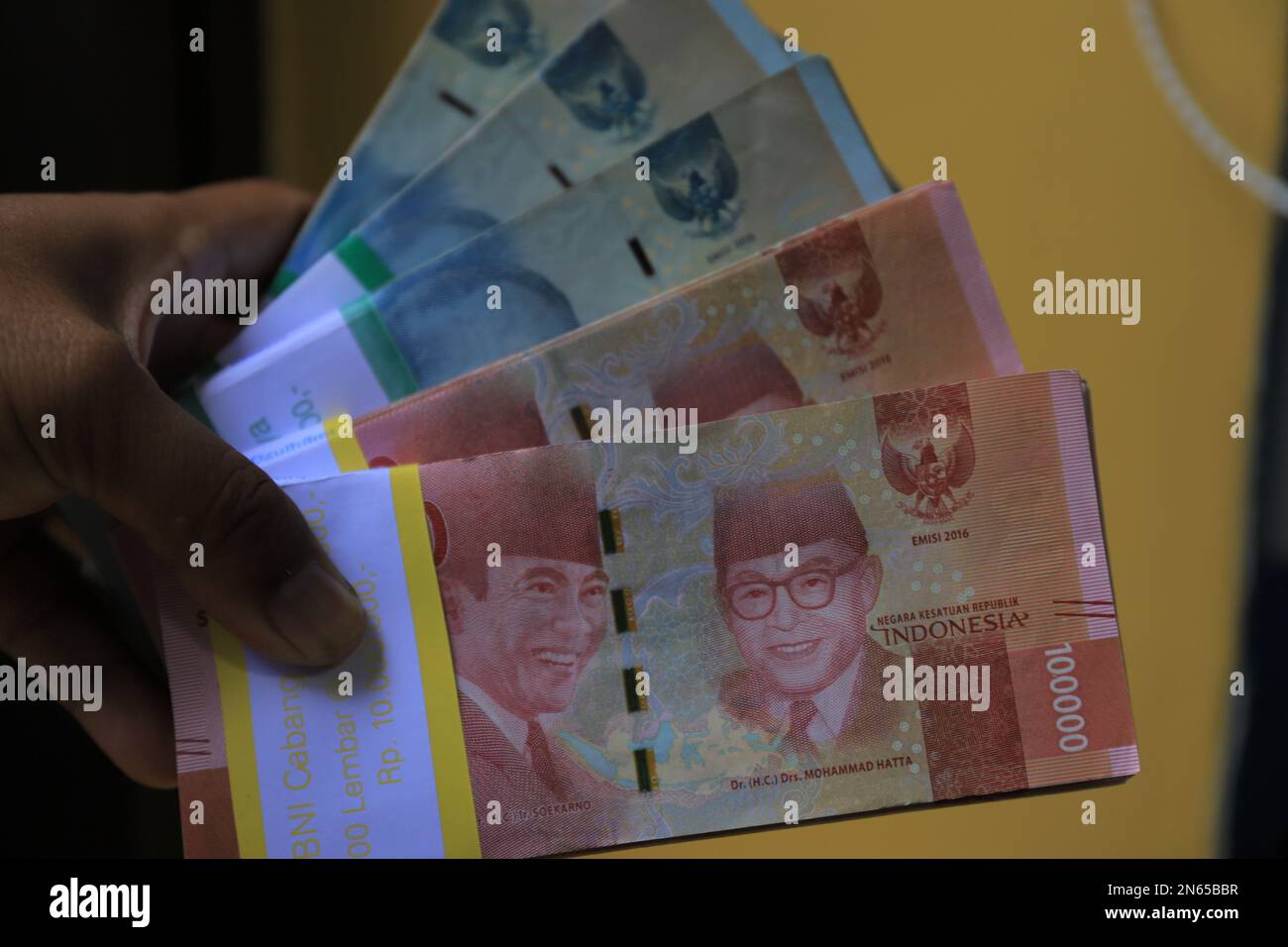 stacks of IDR 100,000 and IDR 50,000 rupiah banknotes on black ...