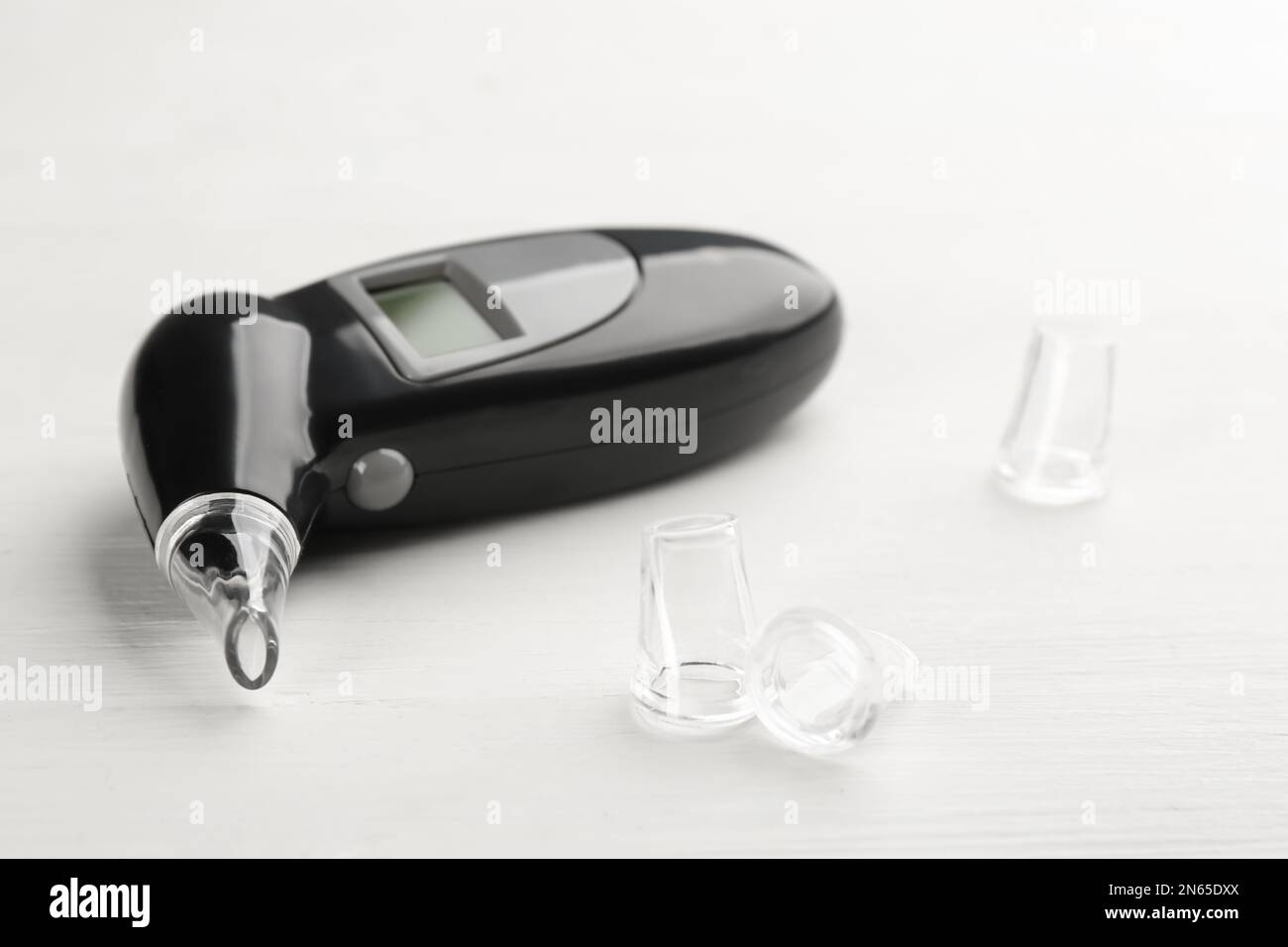 Modern breathalyzer and mouthpieces on white wooden background Stock ...