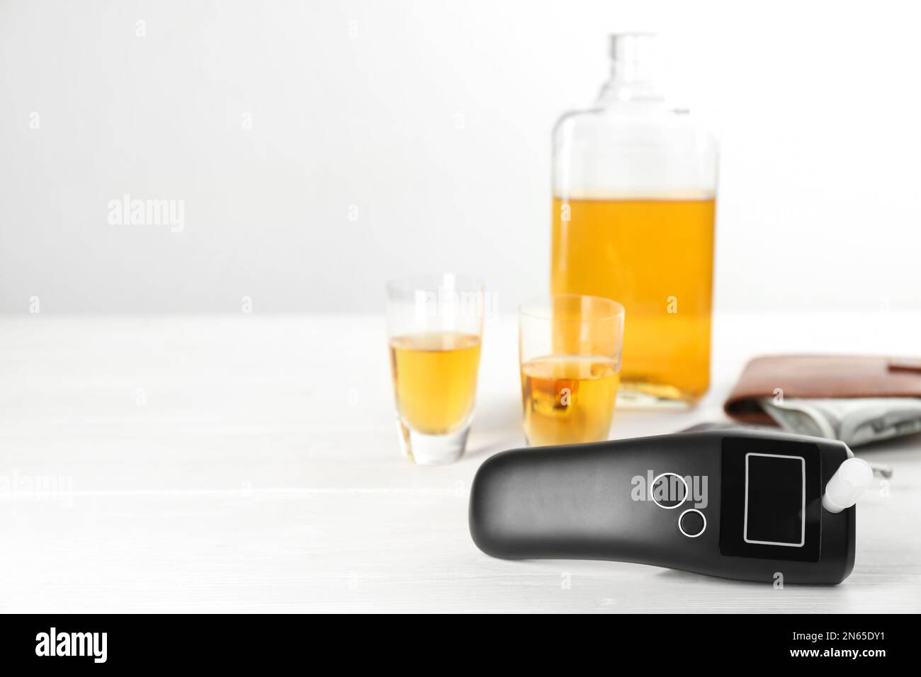 Modern breathalyzer and alcohol on white table. Space for text Stock ...