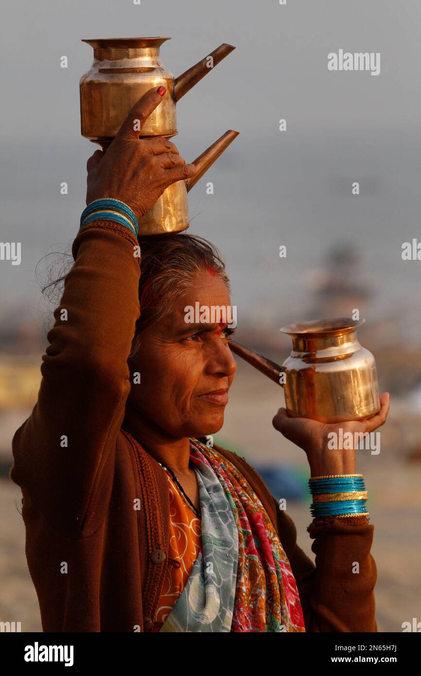 An Indian Hindu devotee carries water from the Ganges River, holy to ...