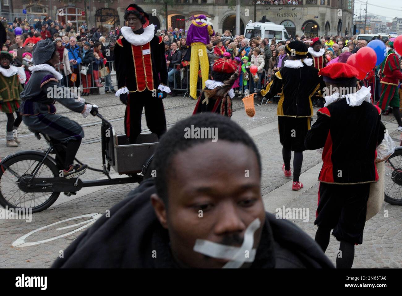 A demonstrator, foreground, turns his back to the parade of Sinterklaas ...