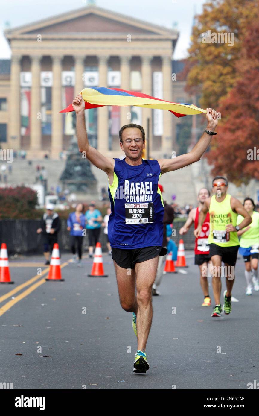 A runner carrying the Colombian flag celebrates as he crosses the ...