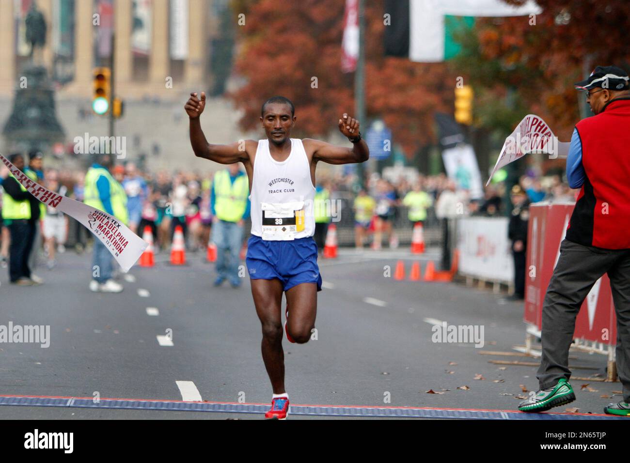 Abebe Mekuriya, of Ethiopia, crosses the finish line, with an ...