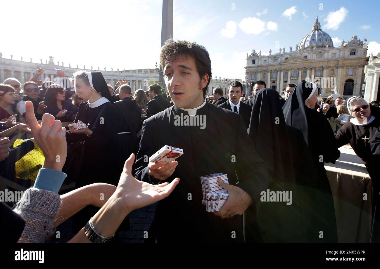 A priest distributes boxes shaped like pills boxes but which contain a ...