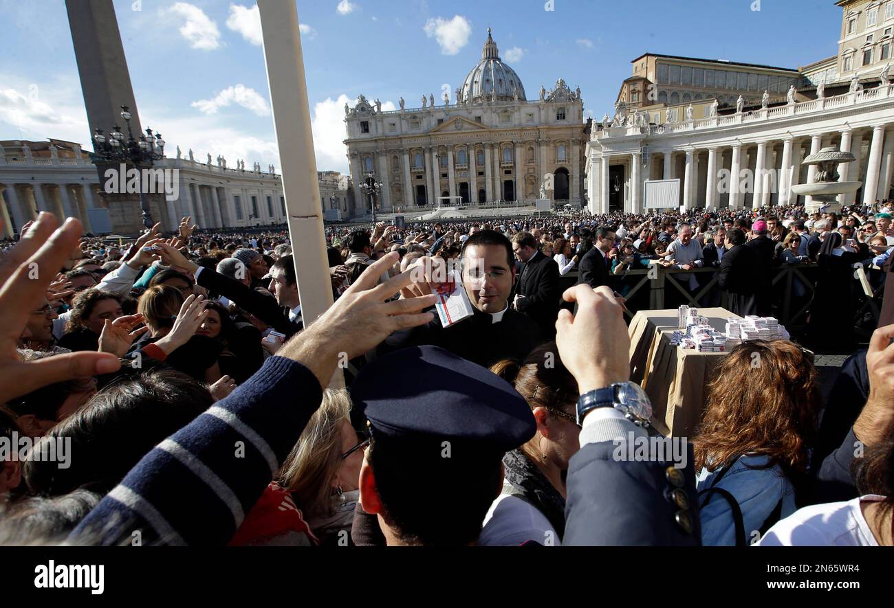 A priest distributes boxes shaped like pills boxes but which contain a ...