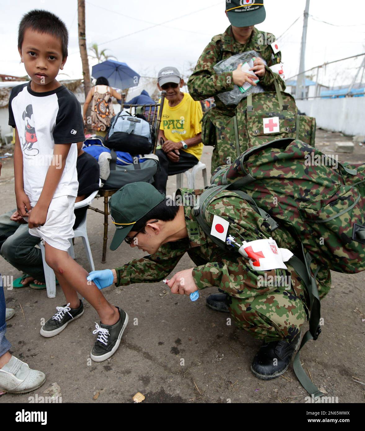Japanese medical team's member treats typhoon survivors as they wait to ...