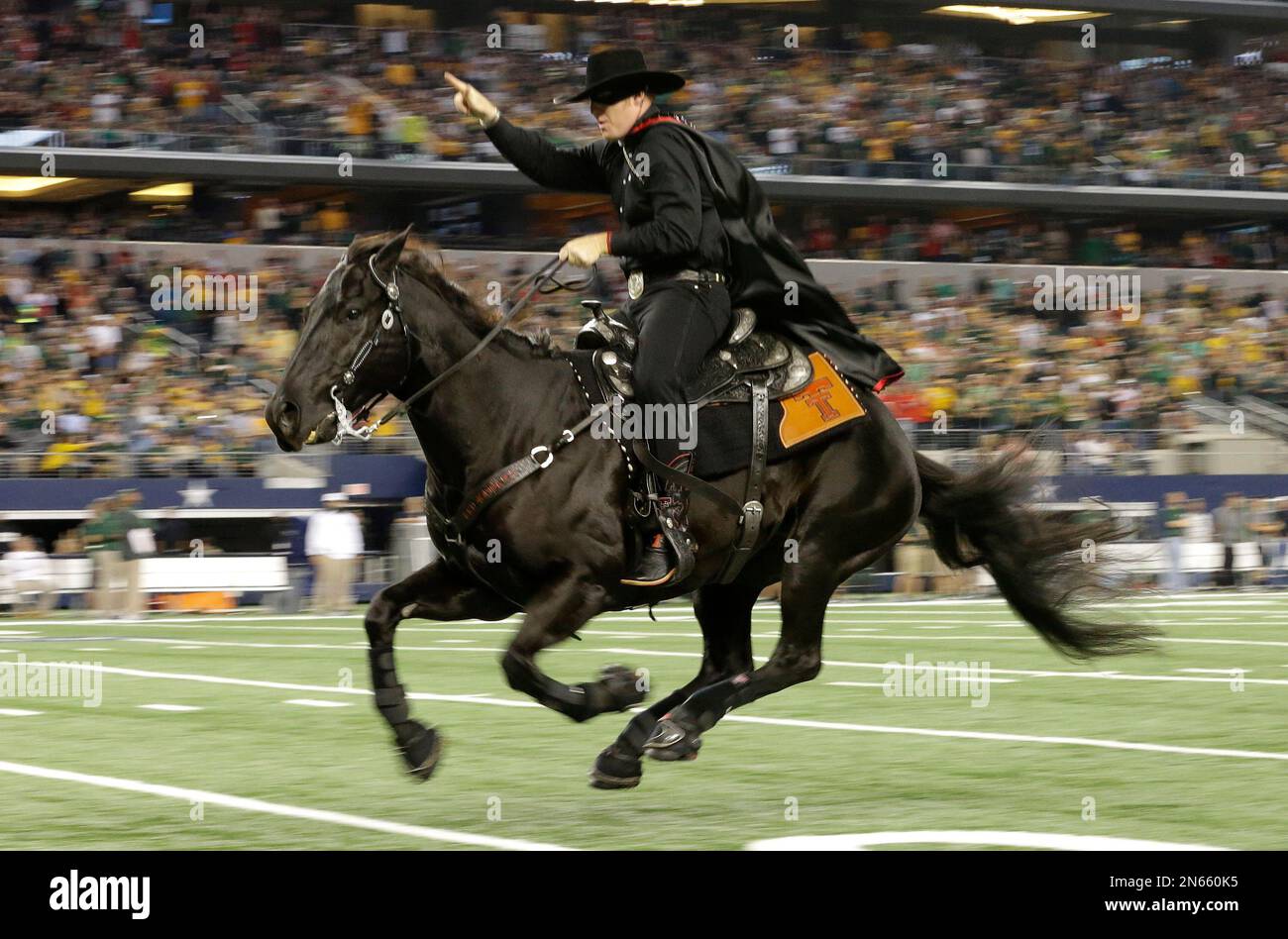 The Texas Tech mascot the Red Raider rides across the field before an ...