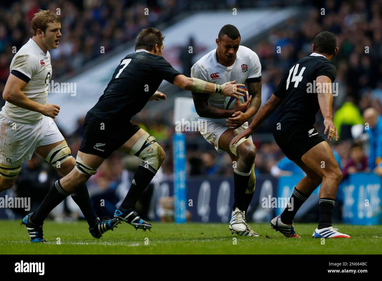 England's Courtney Lawes, second right, is tackled by New Zealand's ...