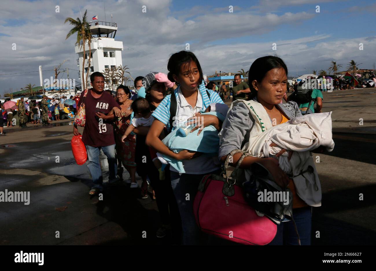 Mothers with their newborns cross the tarmac to an evacuation flight at ...