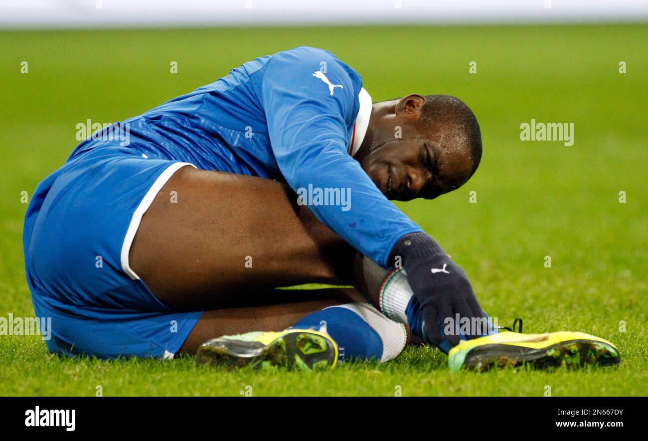 Italy's Mario Balotelli grimaces in pain as he lies on the pitch during ...