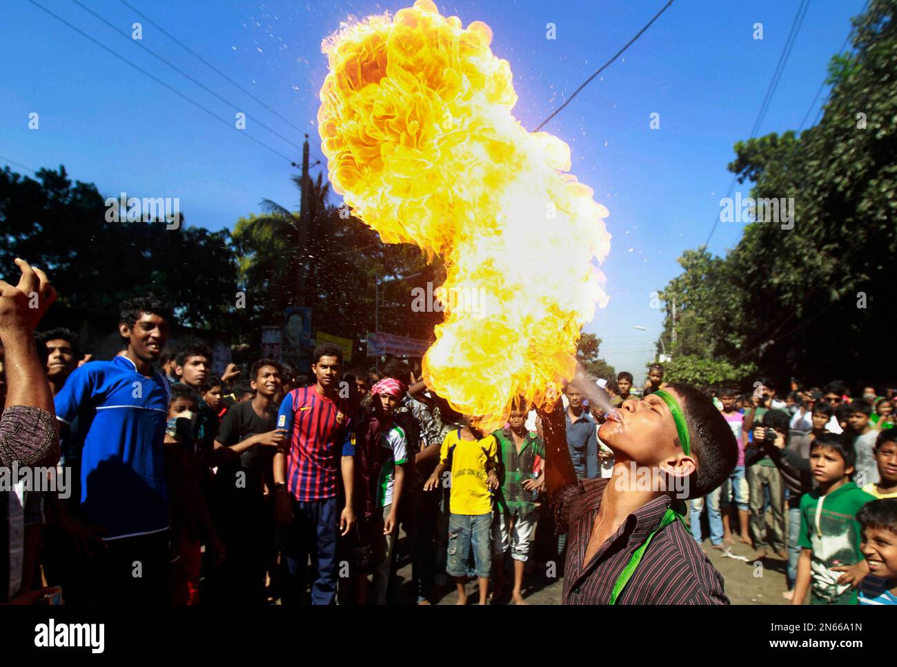 A Bangladeshi Shiite Muslim breathes out fire during Muharram ...