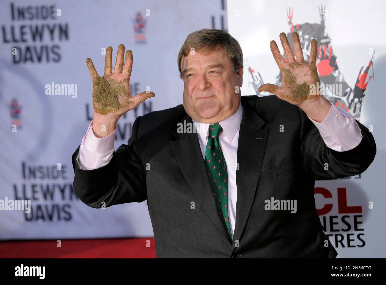 Actor John Goodman shows off his hands after putting them in cement ...