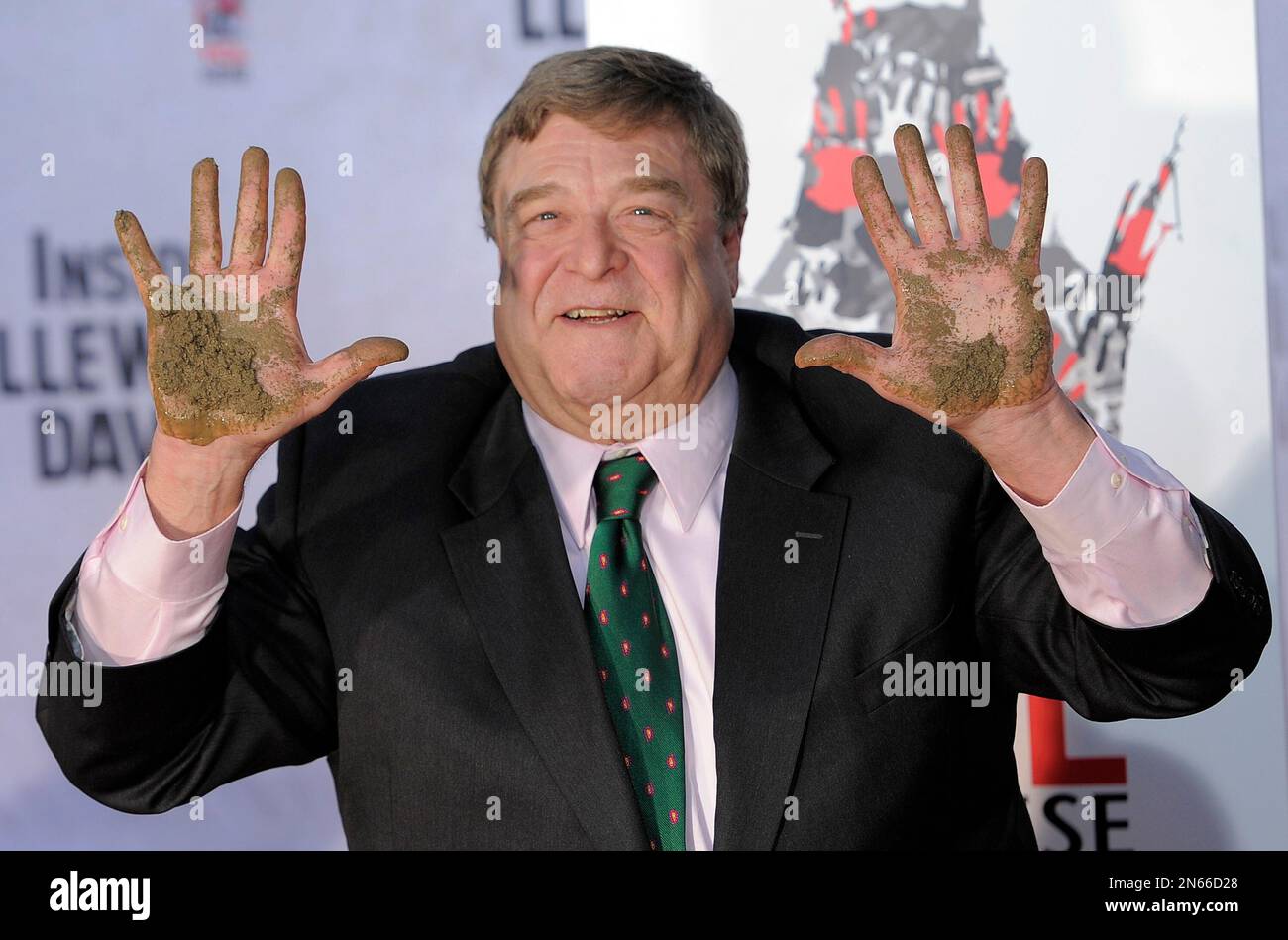 Actor John Goodman shows off his hands after putting them in cement ...