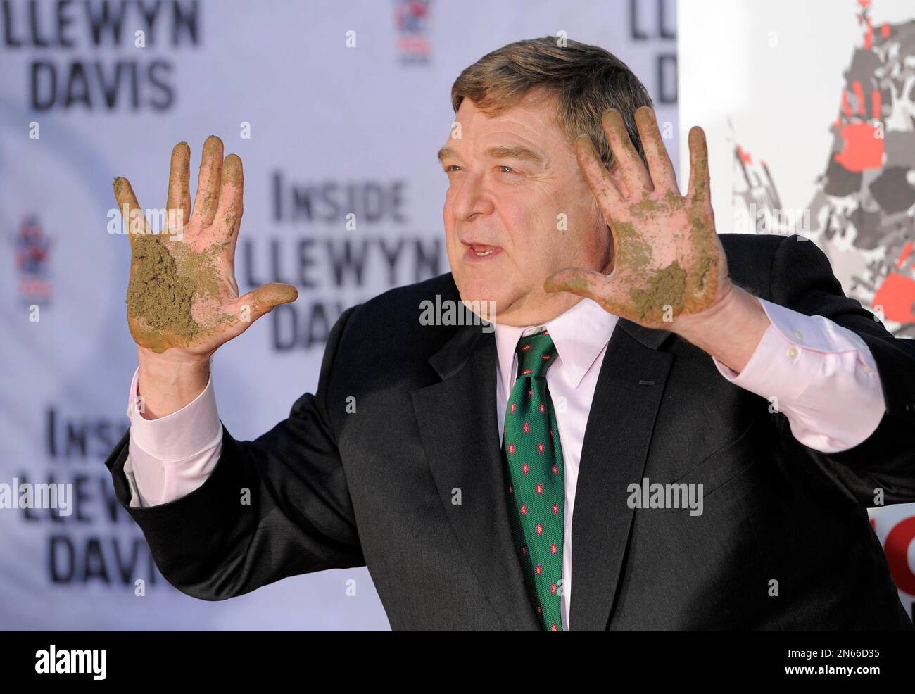Actor John Goodman shows off his hands after putting them in cement ...
