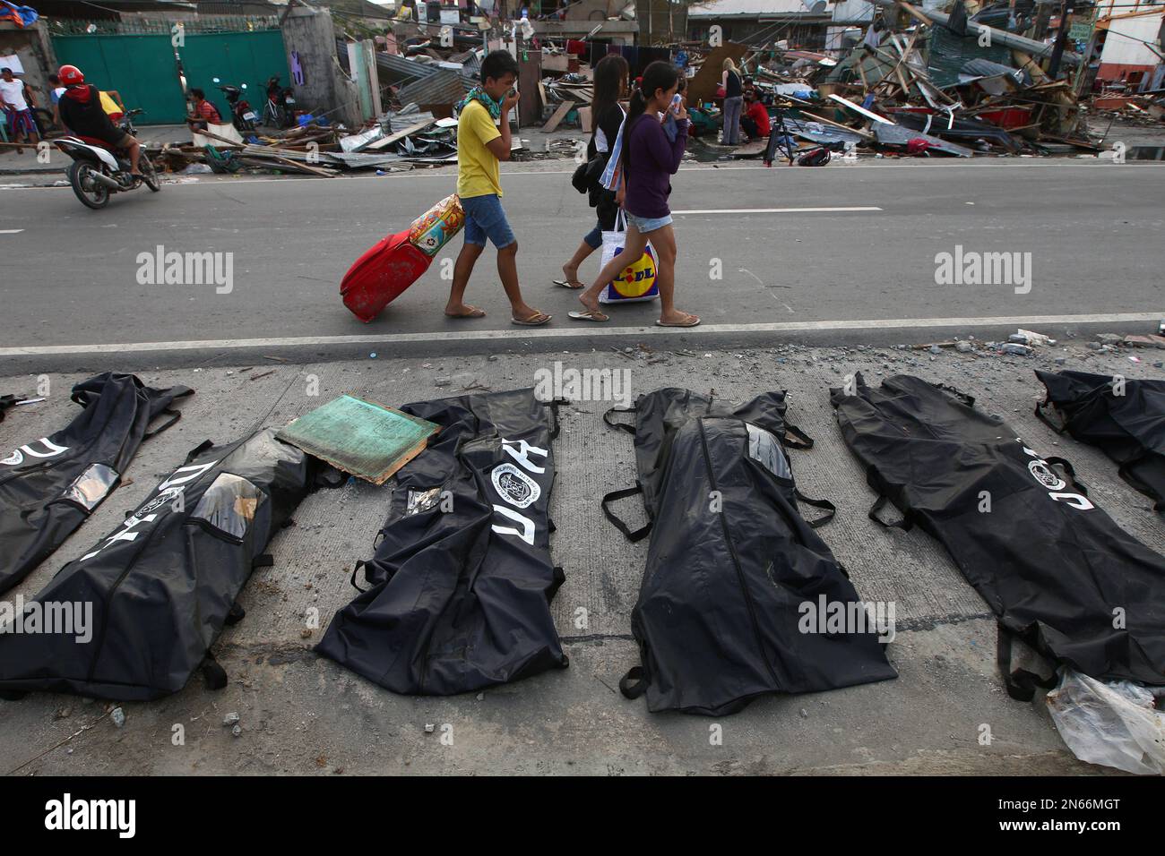People cover their noses from the stench of dead bodies in an area ...