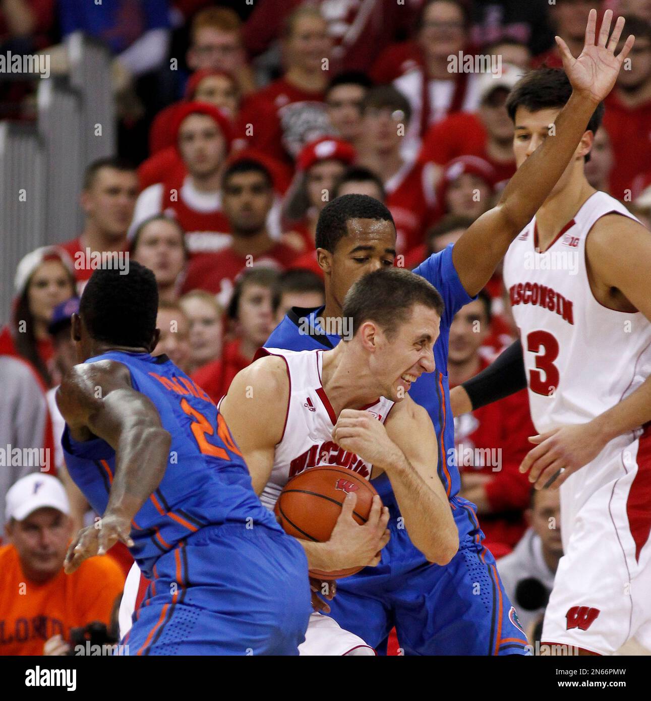 Wisconsin's Josh Gasser, center, drives between Florida's Casey Prather ...