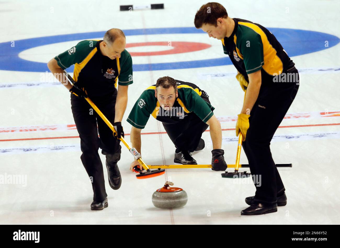 Australia's Duncan Clark, center, releases his stone as teammates Ian ...
