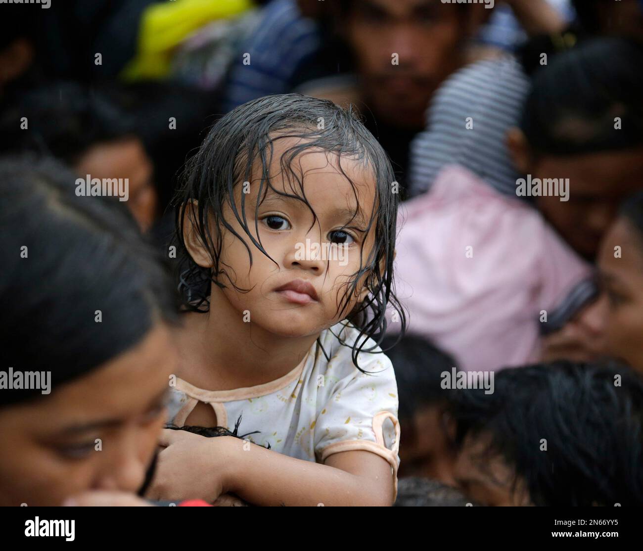A child waits with fellow typhoon survivors as they line up in the ...