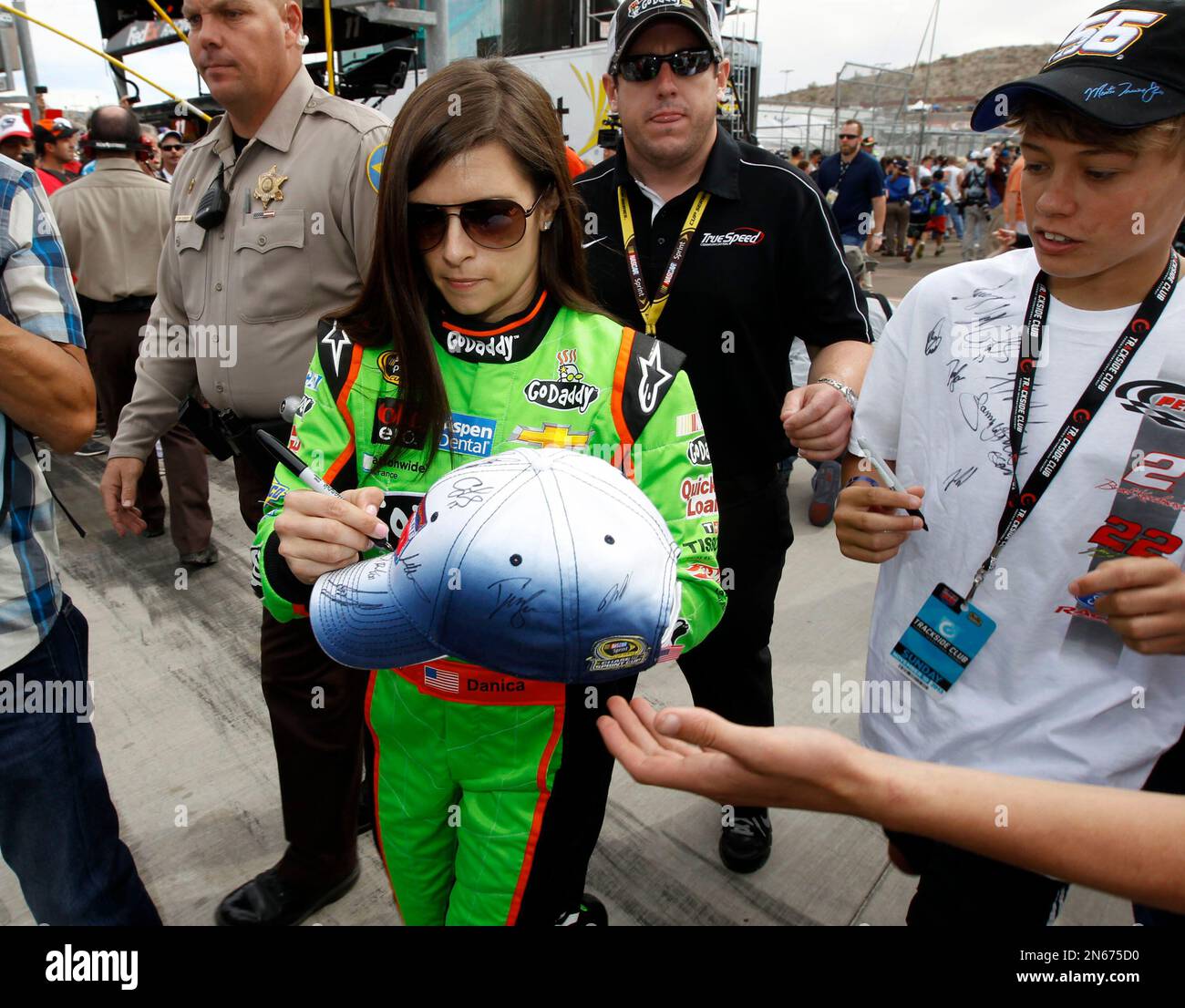 Driver Danica Patrick signs an autograph for a young fan as she makes ...
