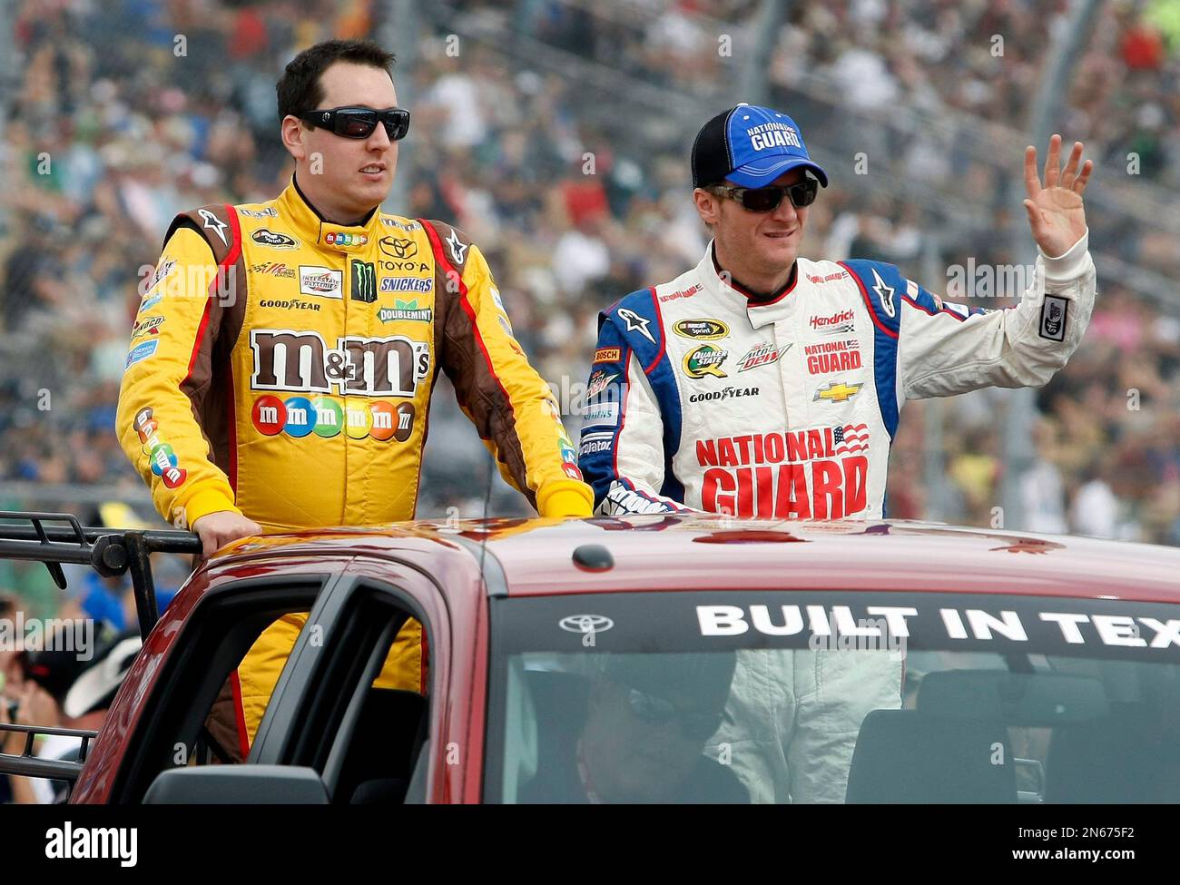 Dale Earnhardt Jr, right, waves to the crowd next to fellow driver Kyle ...