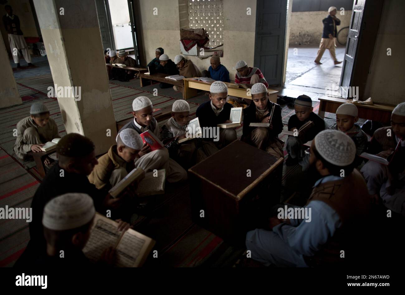 Pakistani students of a madrassa, or Islamic school, gather around ...