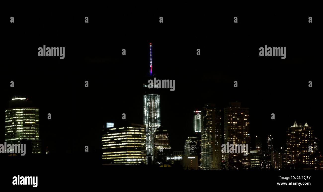 The beacon and spire of One World Trade Center are lit up, as seen from ...