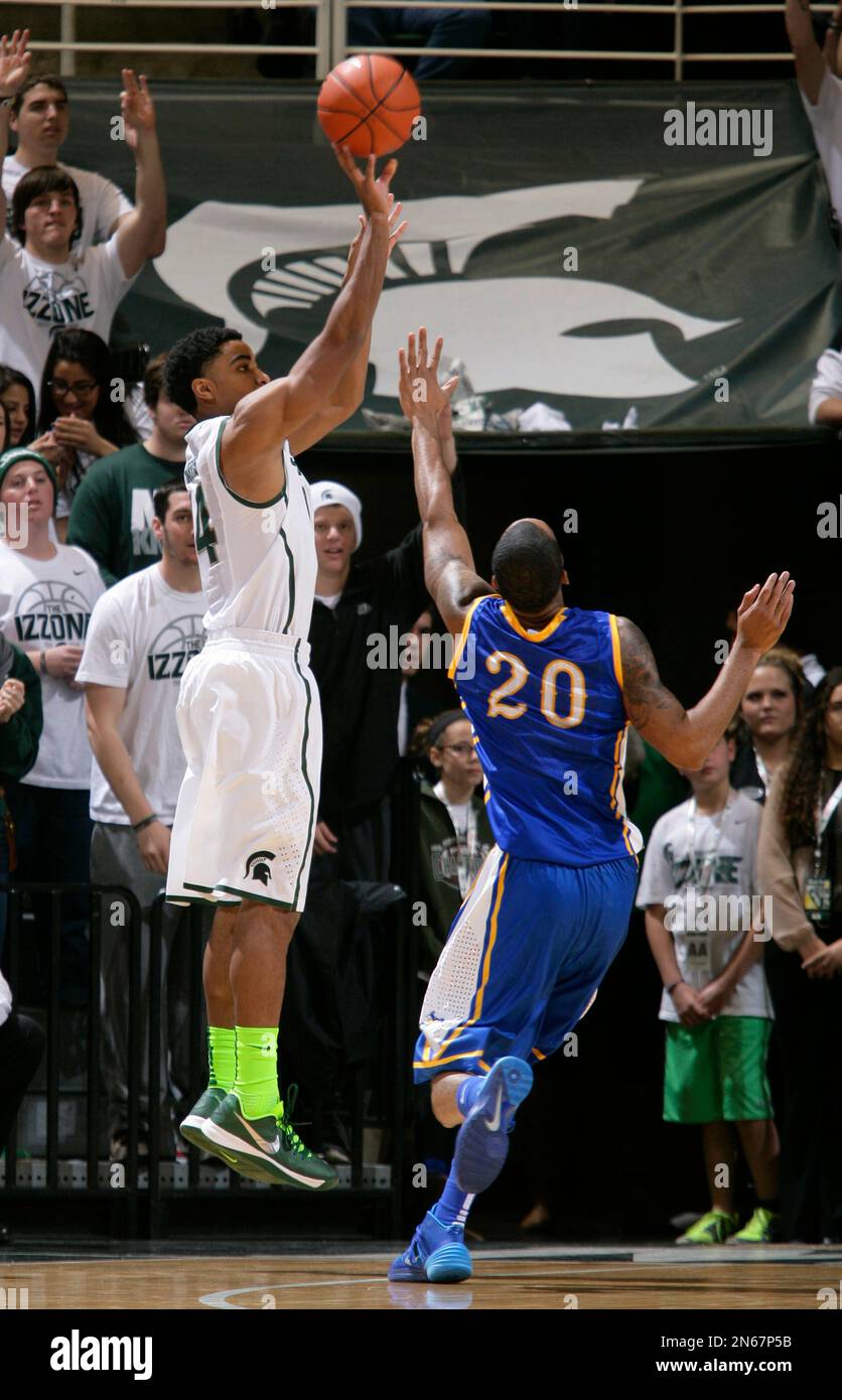 Michigan State's Gary Harris, left, shoots a 3-pointer over McNeese ...