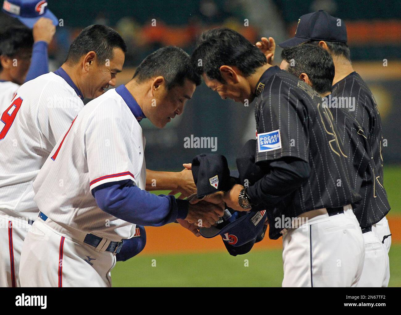 Japan's manager Hiroki Kokubo, right, shakes hands with Taiwan's ...