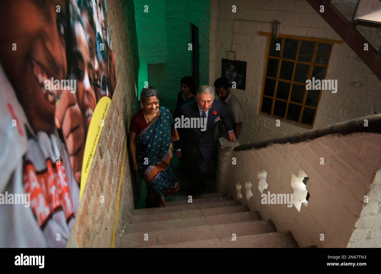 Britain's Prince Charles climbs up a staircase accompanied by a school ...