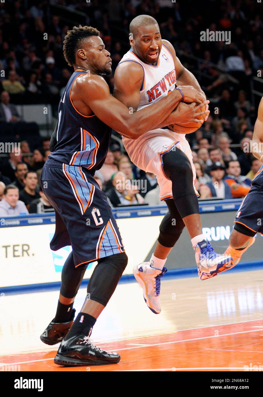 Charlotte Bobcats' Jeff Adrien, left, ties up New York Knicks' Raymond ...