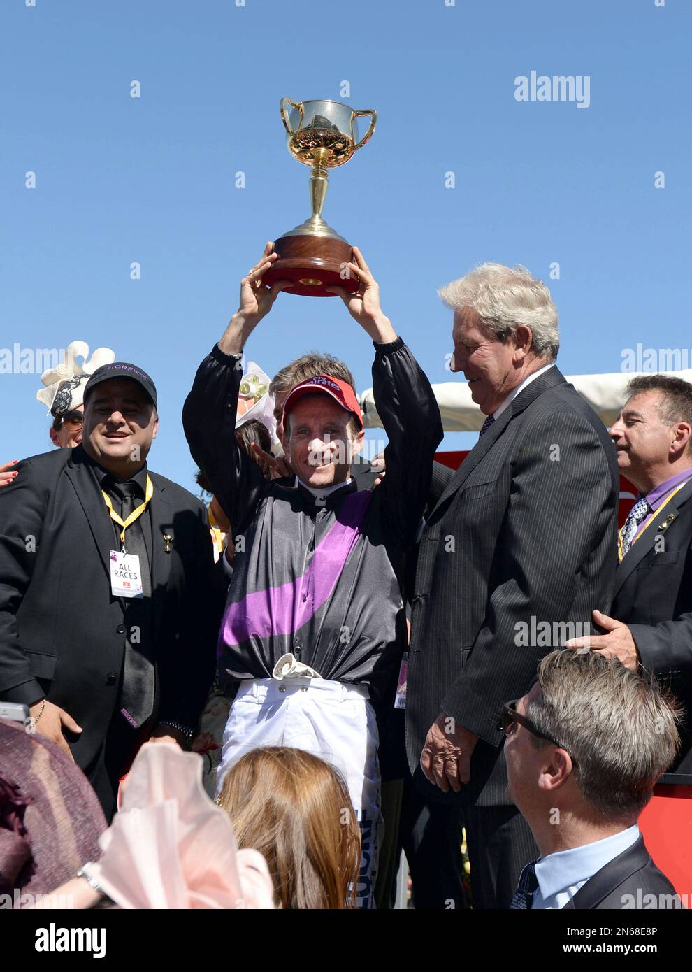 Australian jockey Damien Oliver holds up the trophy after riding ...