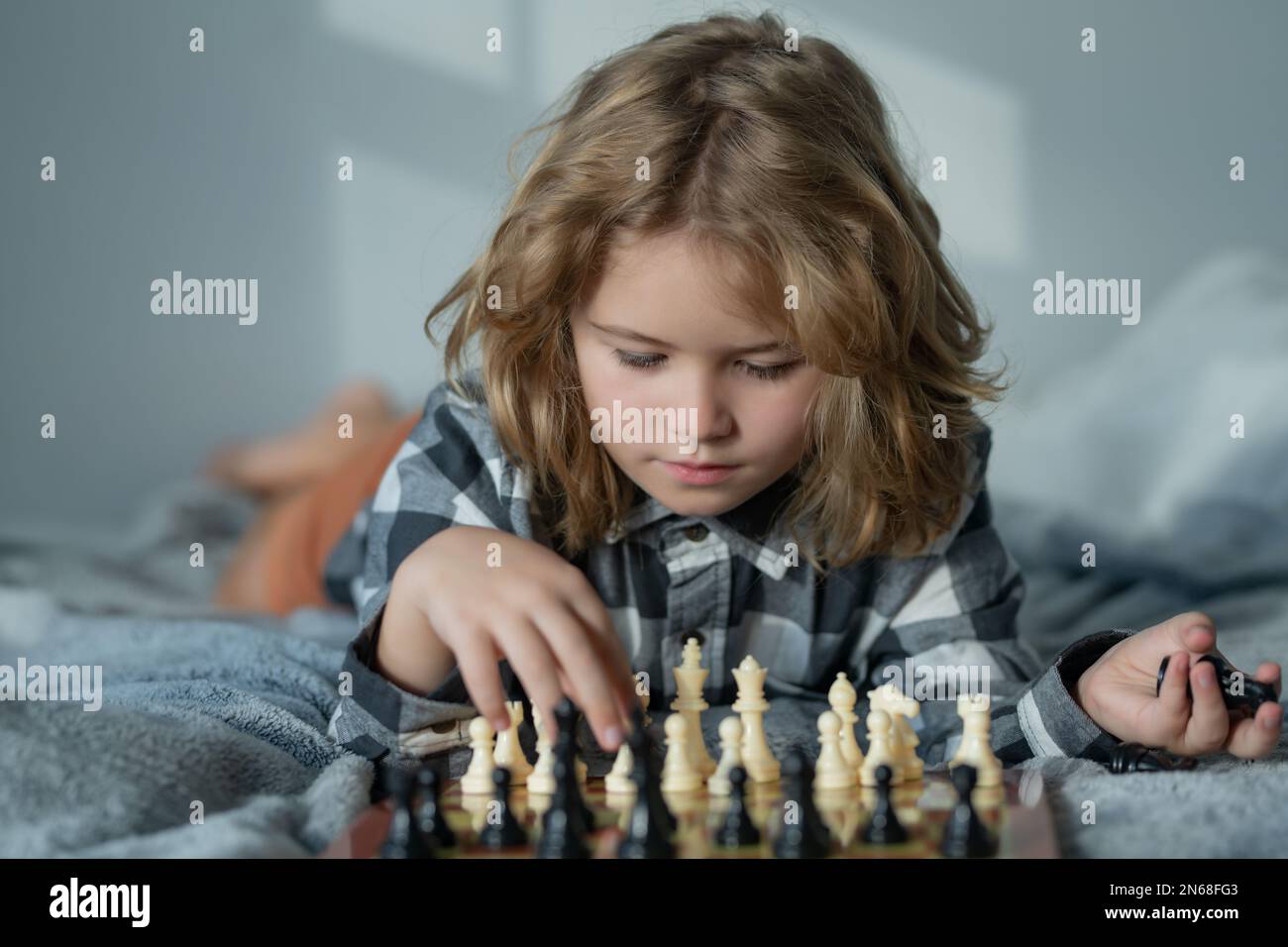 Kid play chess at home. Child think about chess game. Intelligent ...