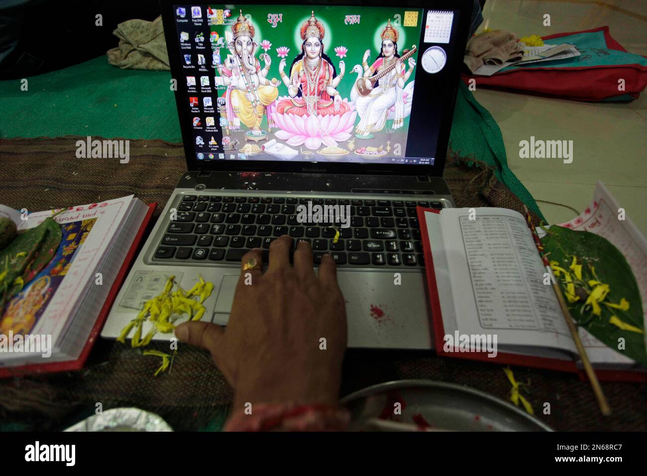 An Indian trader's laptop screen has pictures of Hindu deities as he ...