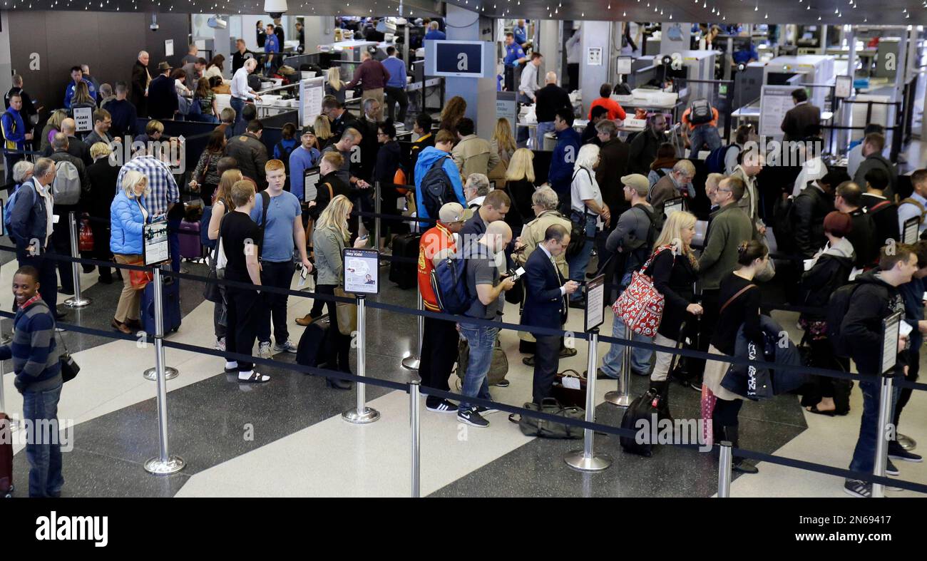 Travelers wait in line at a security check station at Chicago O'Hare ...