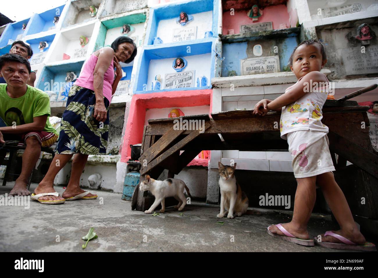 A family of informal settlers prepare their meals next to multi-level ...