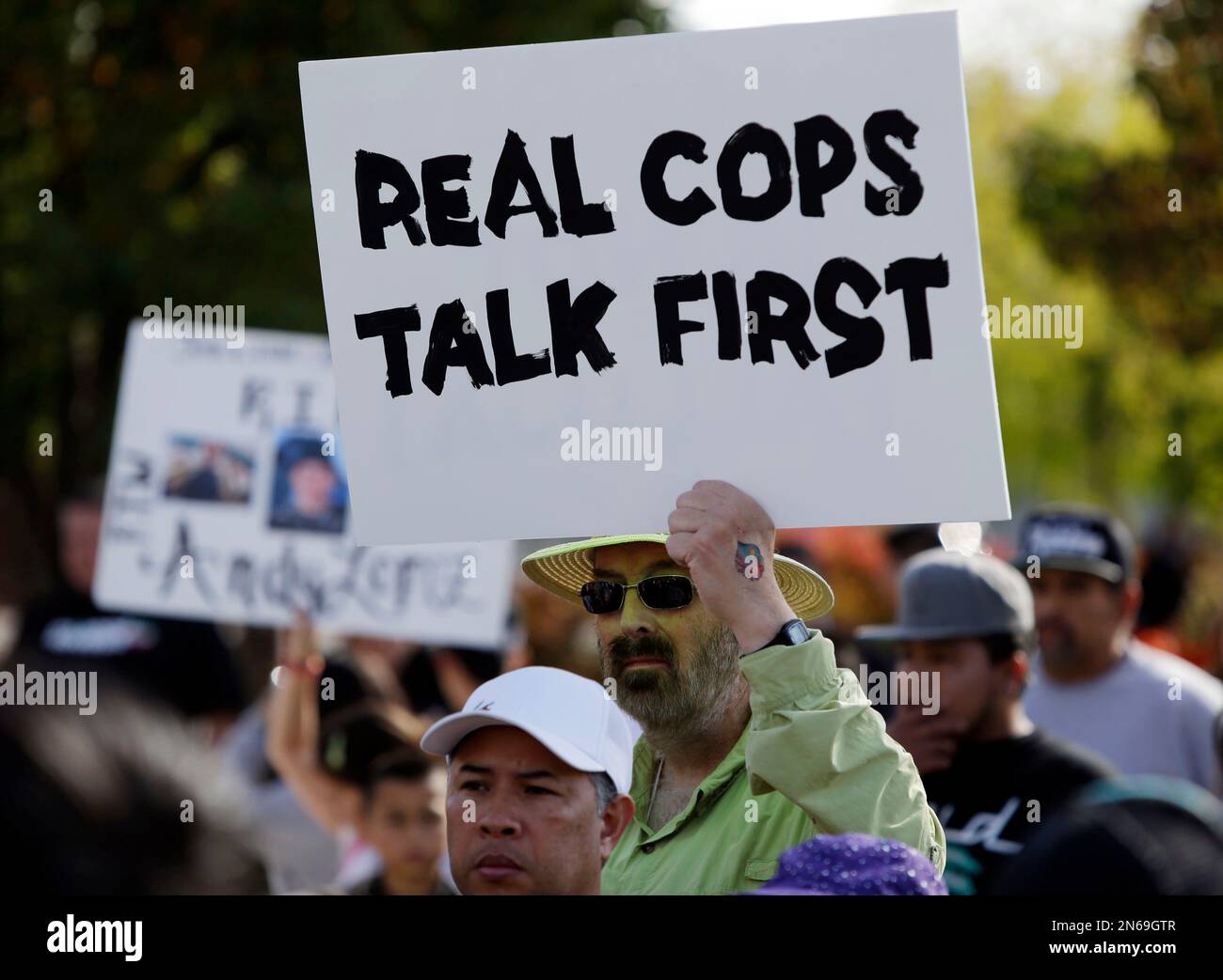 A protester hold a sign in reaction to a police shooting outside of the ...