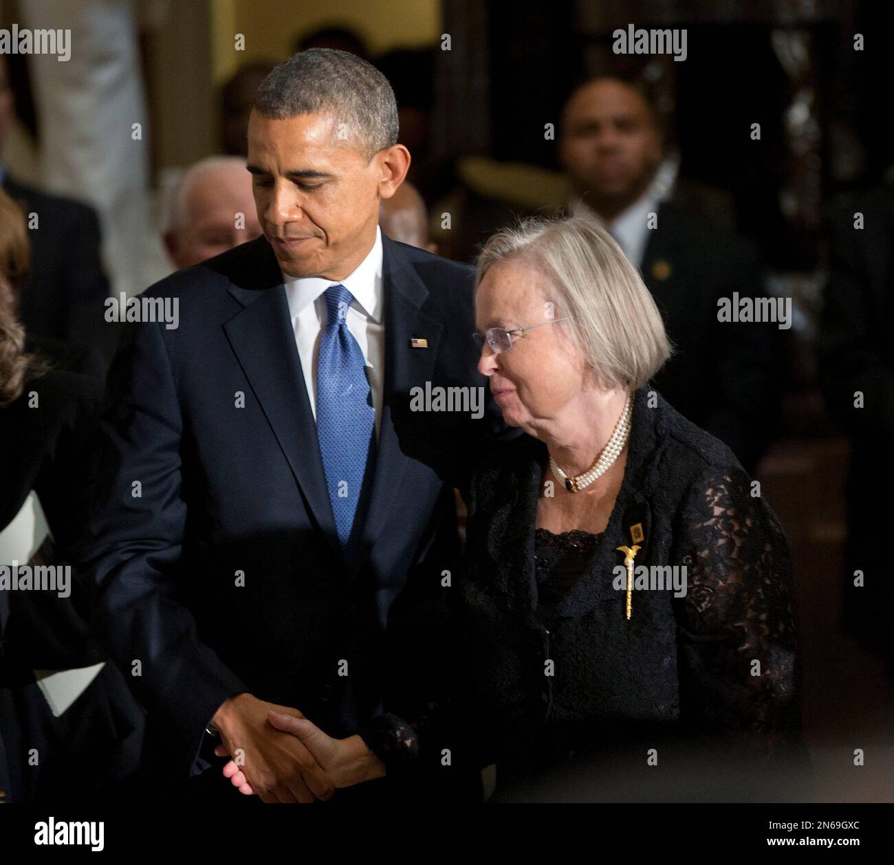 President Barack Obama holds the hand of Heather Foley, widow of former ...