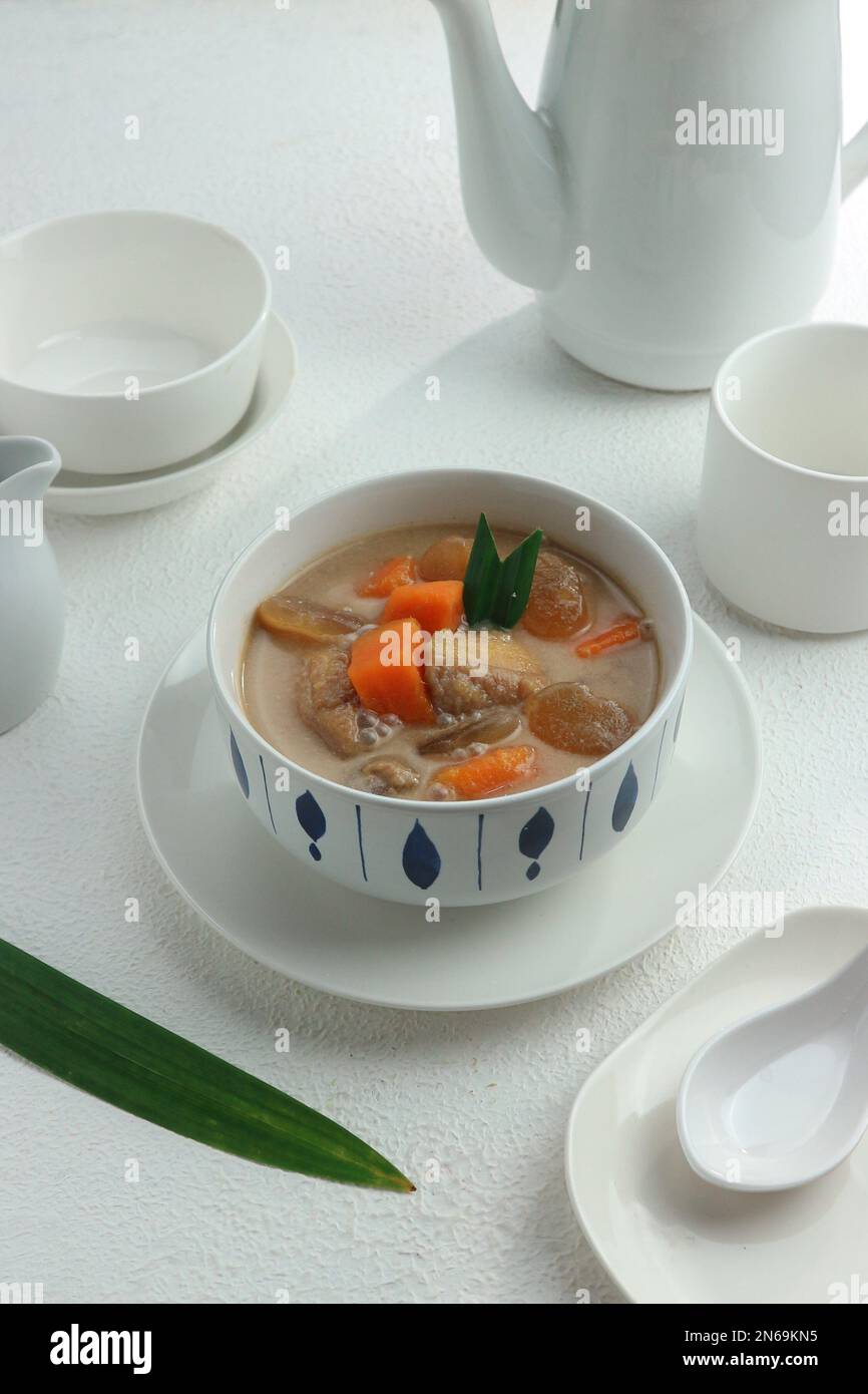 a bowl of banana and sweet potato compote on a tea set background Stock ...