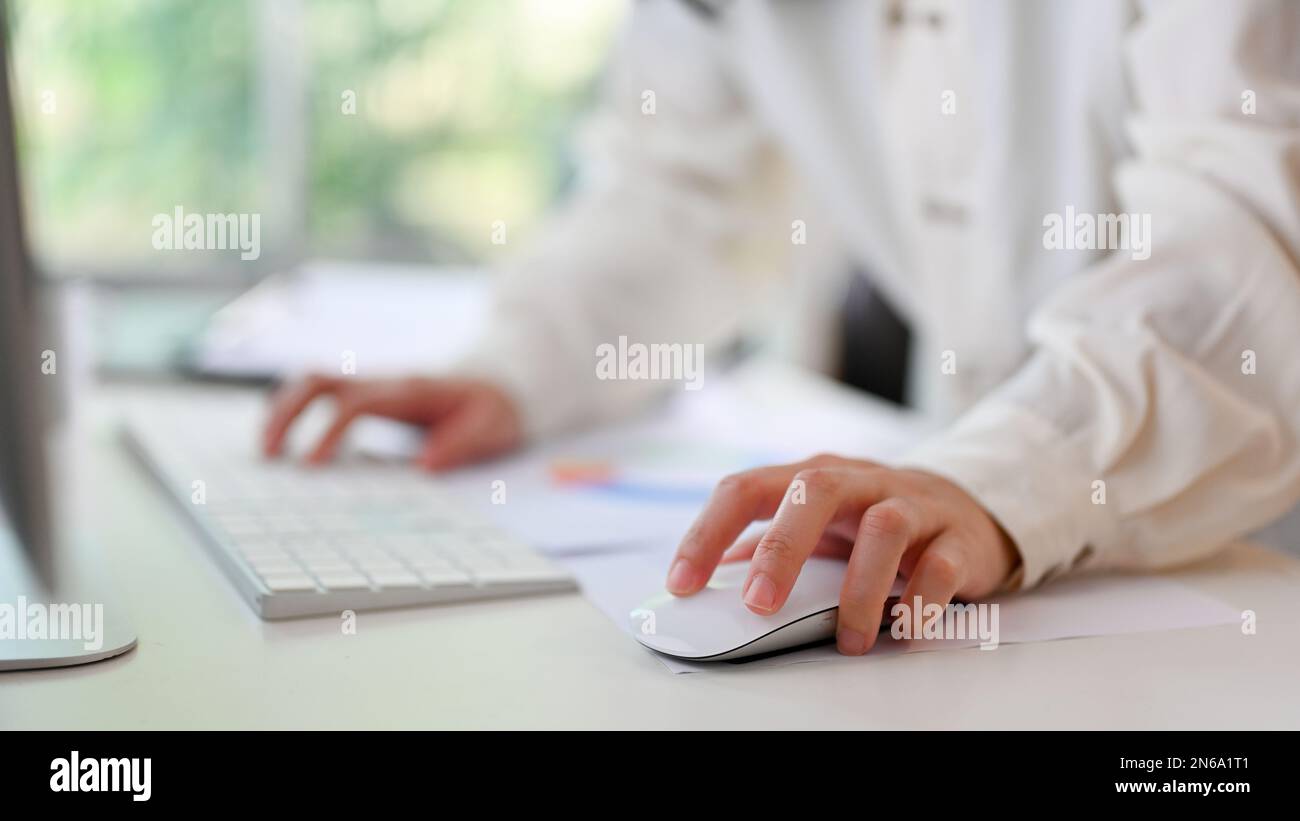 Close-up hand image, A businesswoman using a wireless mouse, working on ...