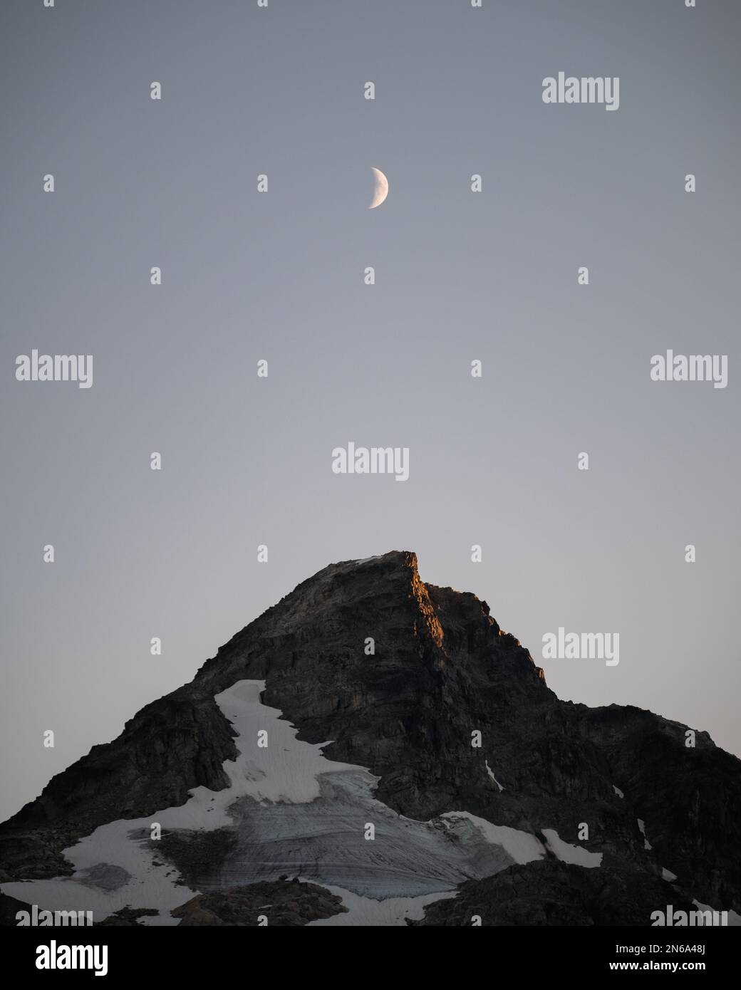 Moon over mountain peak Stock Photo - Alamy