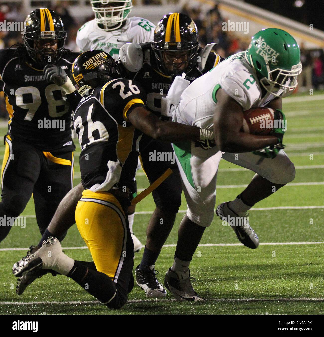 North Texas running back Reggie Pegram (2) tries to break the tackle of ...